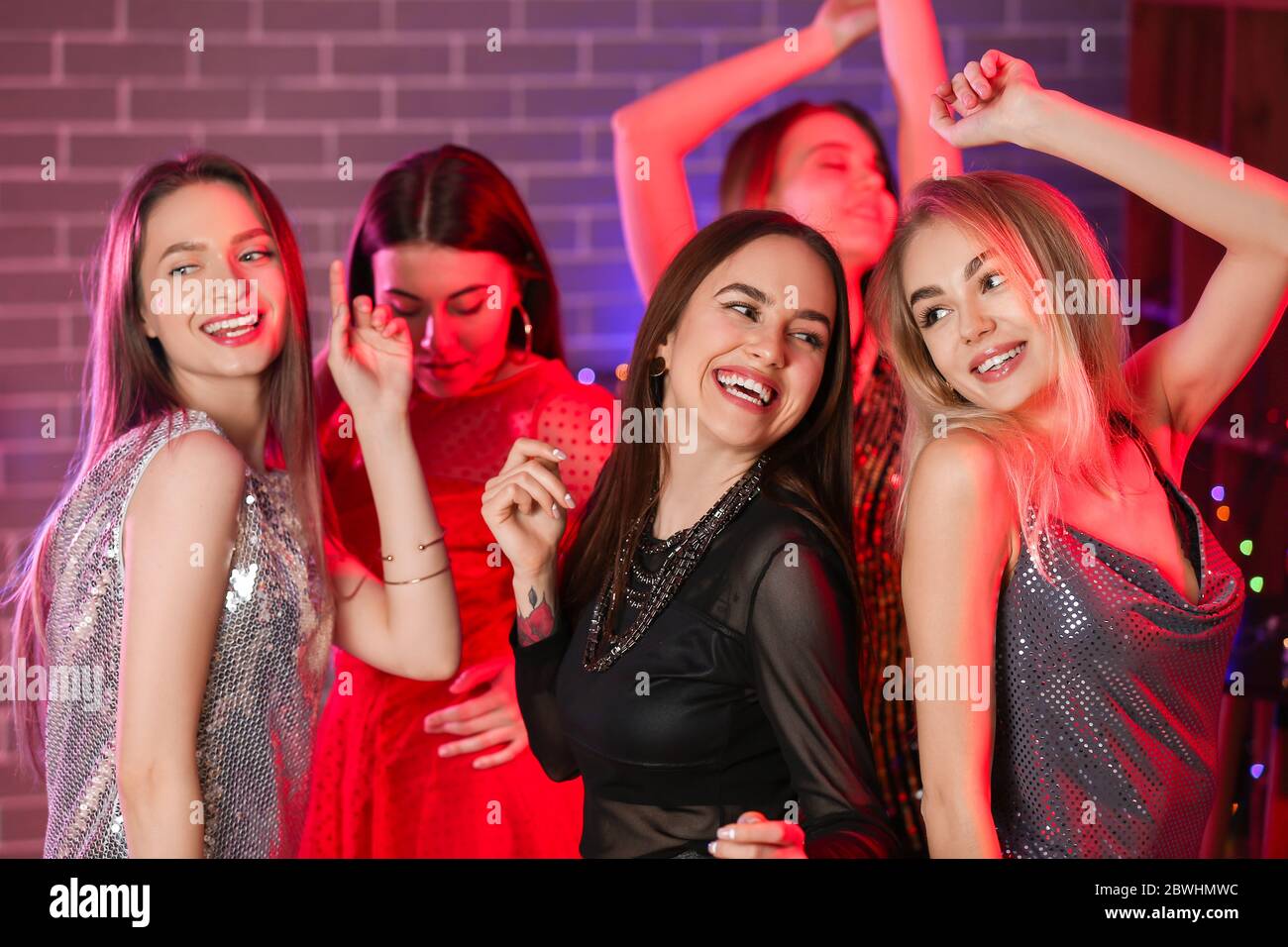 Beautiful young women dancing in night club Stock Photo - Alamy