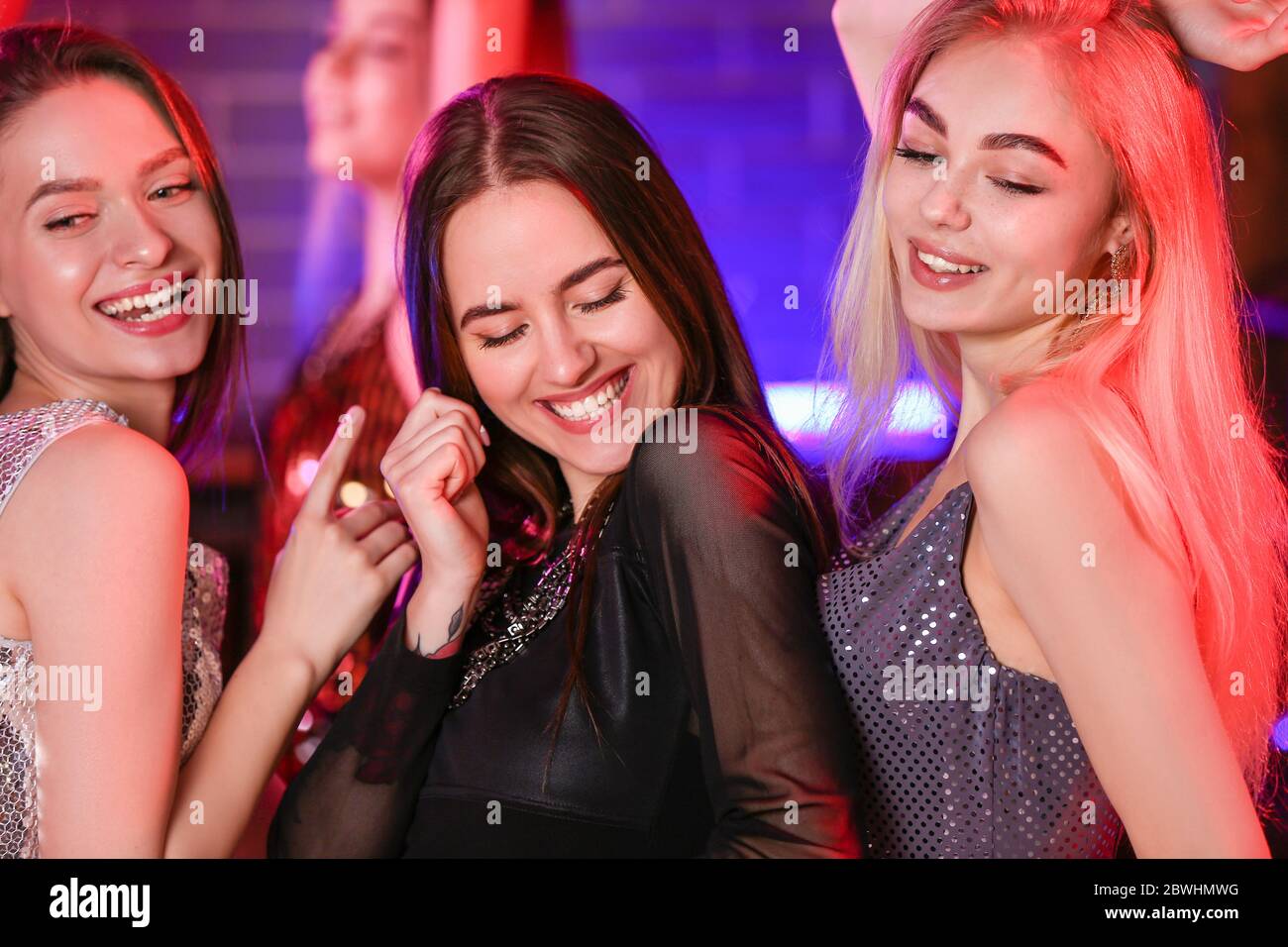 Beautiful young women dancing in night club Stock Photo - Alamy