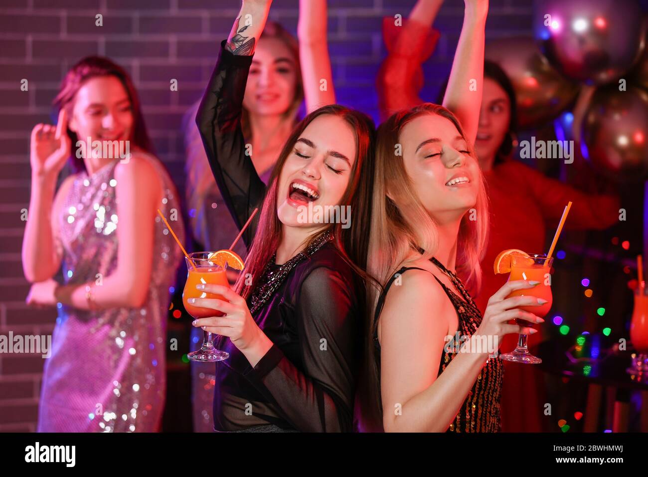 Beautiful young women dancing in night club Stock Photo - Alamy