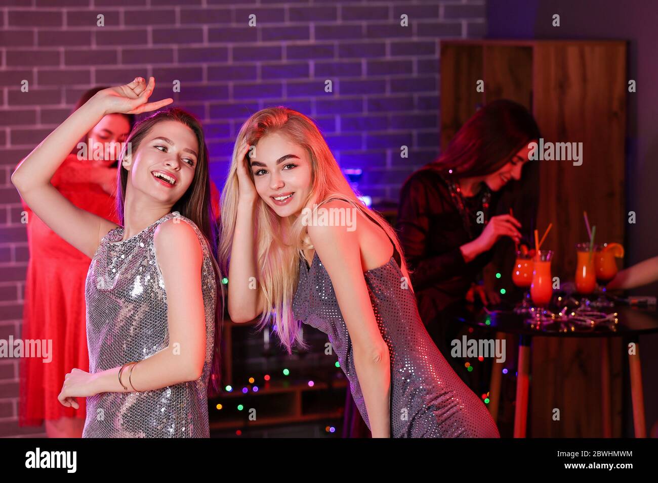 Beautiful young women dancing in night club Stock Photo - Alamy