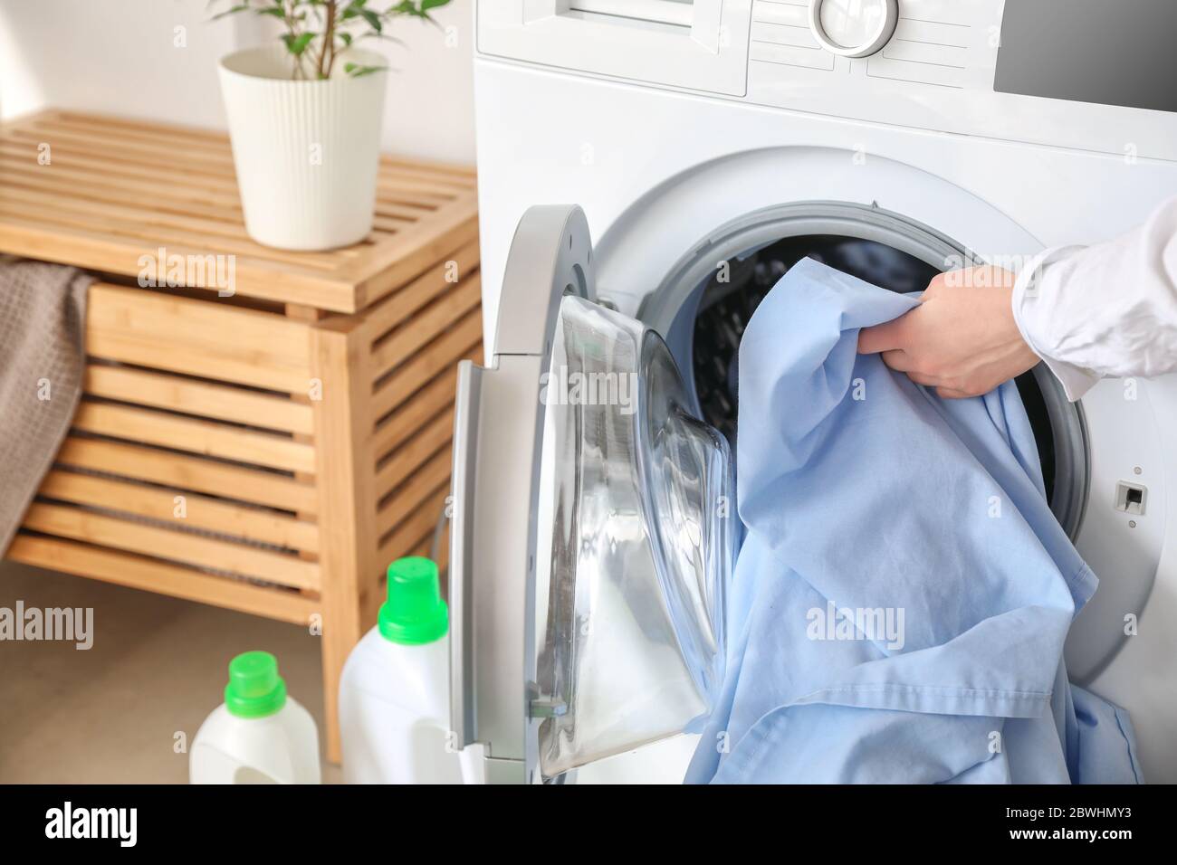 Young woman doing laundry at home Stock Photo - Alamy
