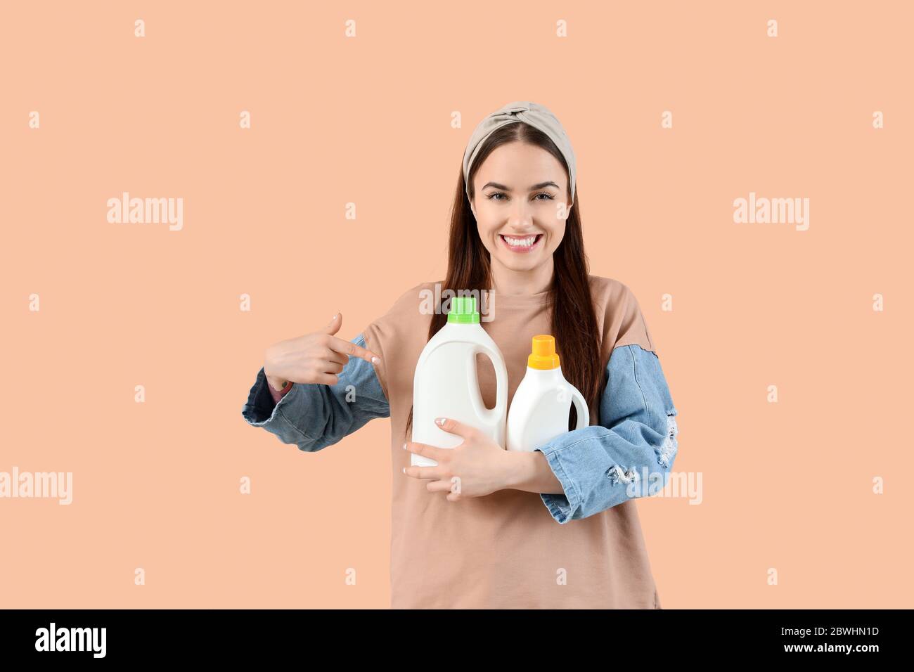 Beautiful young woman with detergents on color background Stock Photo ...