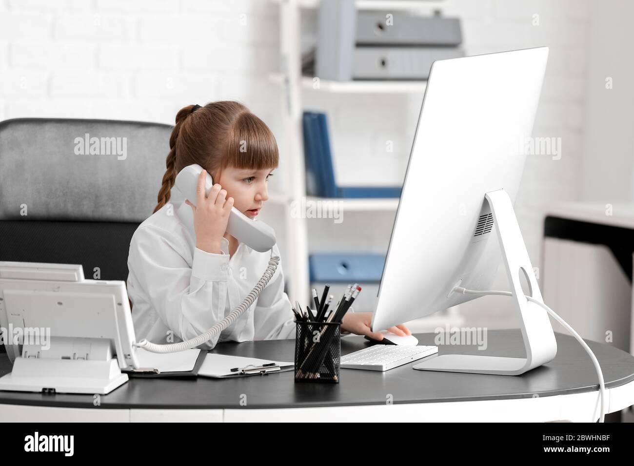Little secretary working in office Stock Photo - Alamy