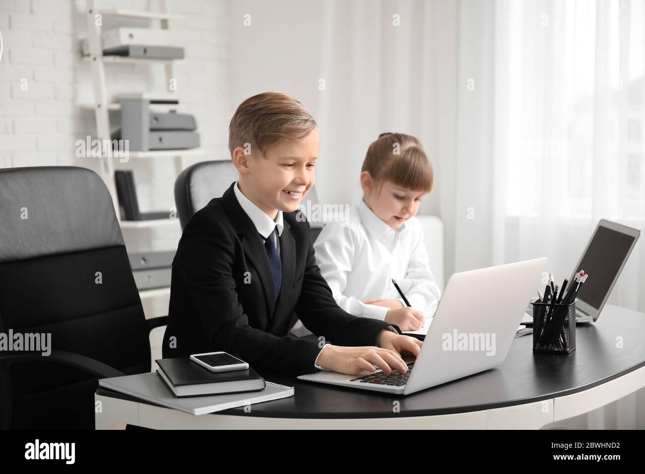 Little secretaries working in office Stock Photo - Alamy