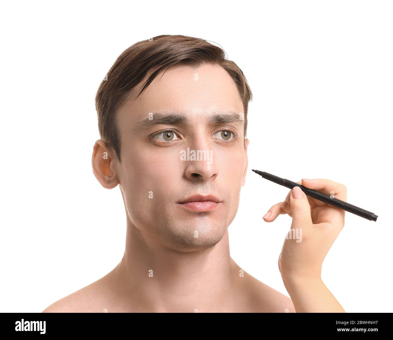 Plastic surgeon applying marking on man's face against white background ...