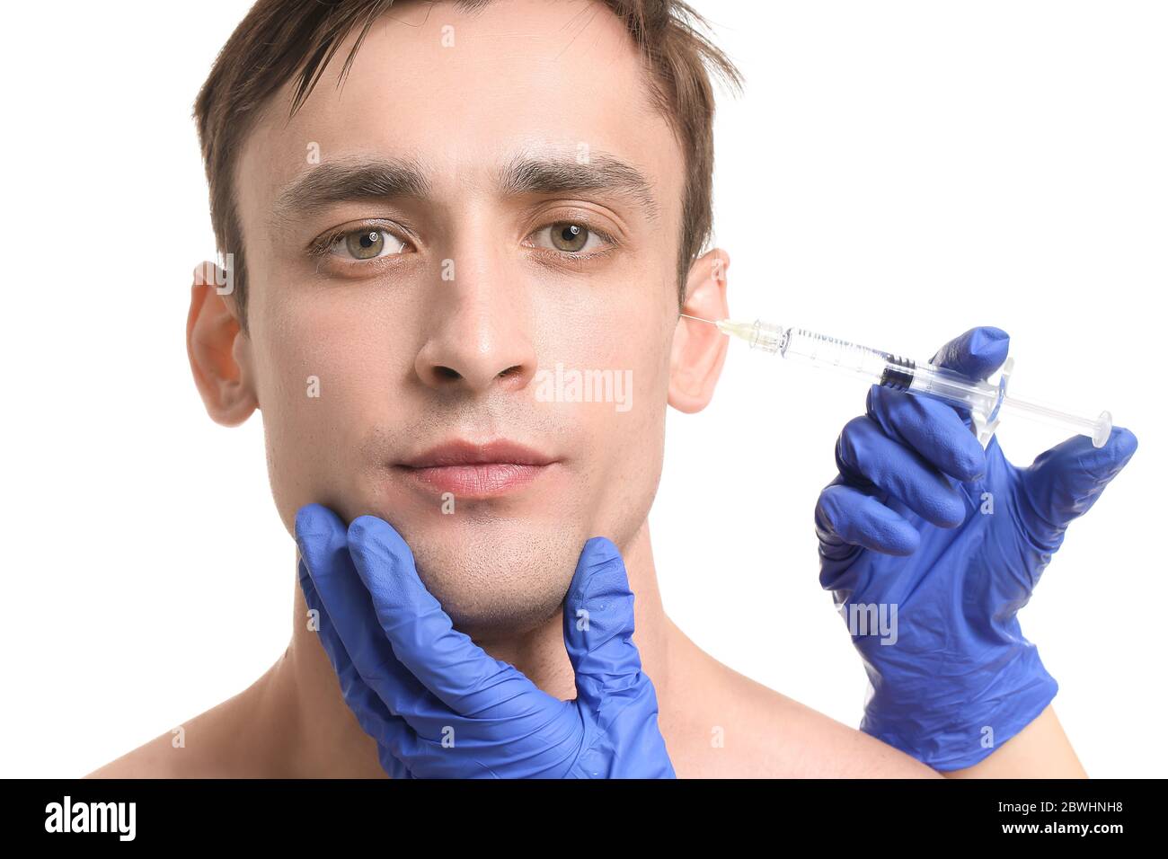 Handsome man receiving filler injection on white background Stock Photo ...