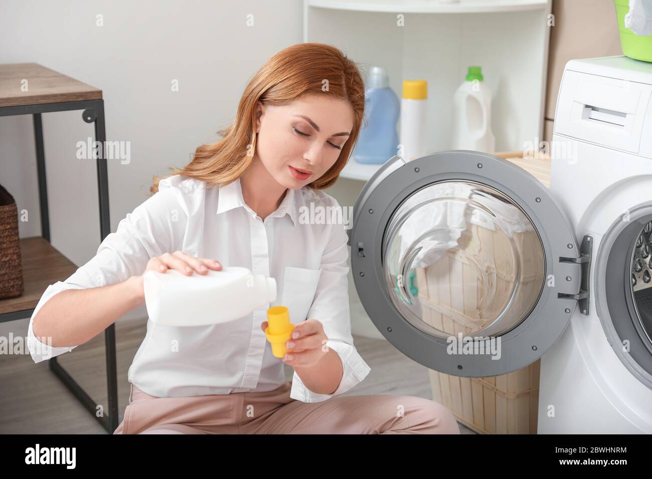 Beautiful woman doing laundry at home Stock Photo - Alamy