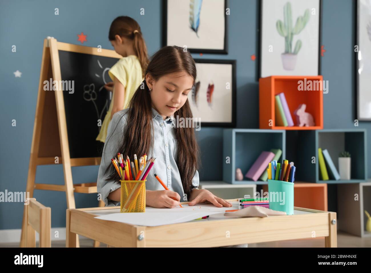 Cute girl drawing at school Stock Photo - Alamy