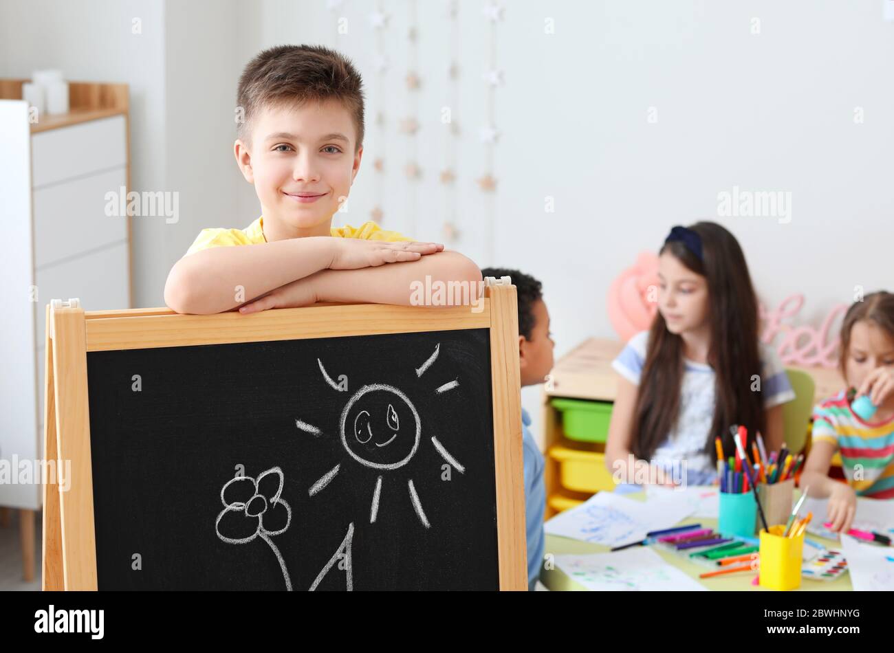 Cute boy drawing at school Stock Photo - Alamy