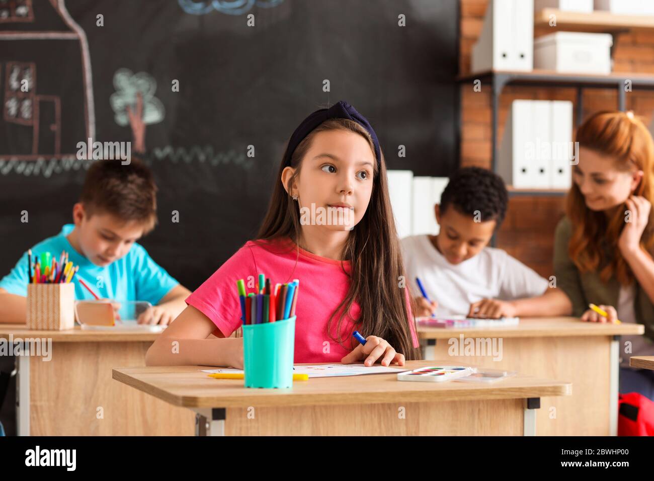 Cute girl drawing at school Stock Photo - Alamy