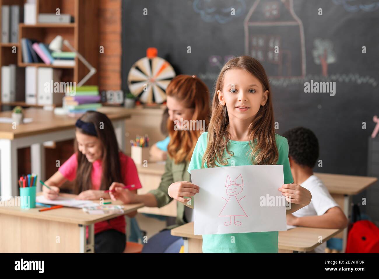 Cute girl with drawing at school Stock Photo - Alamy