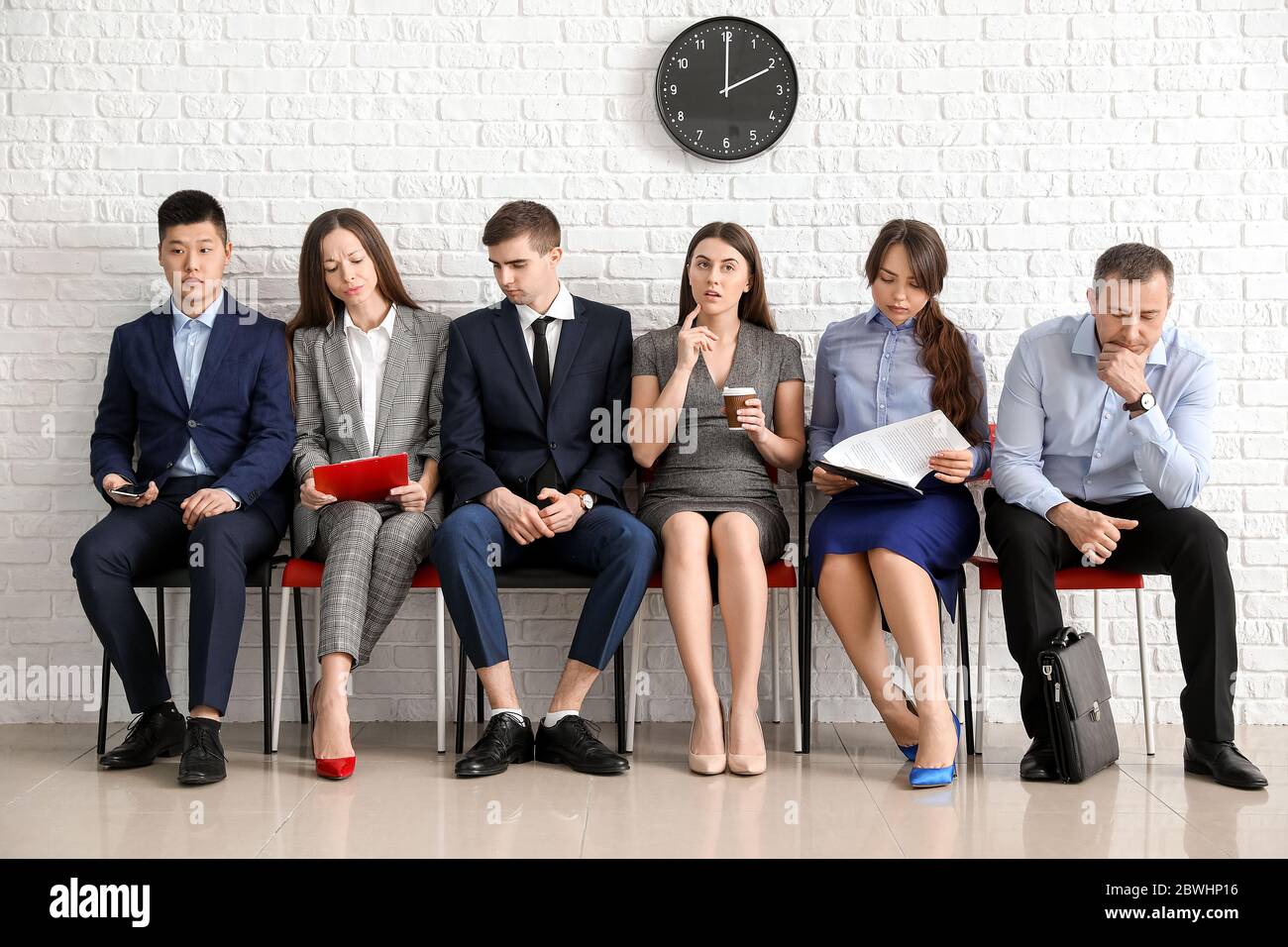 Business people waiting in line indoors Stock Photo - Alamy