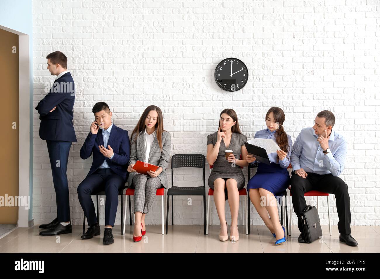 Business people waiting in line indoors Stock Photo - Alamy