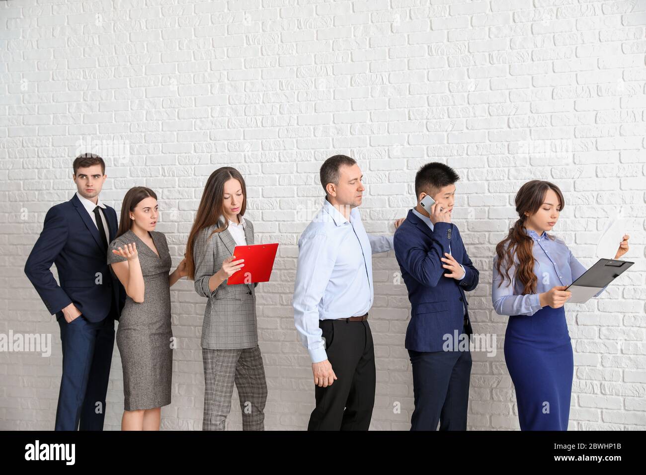 Business people waiting in line indoors Stock Photo - Alamy