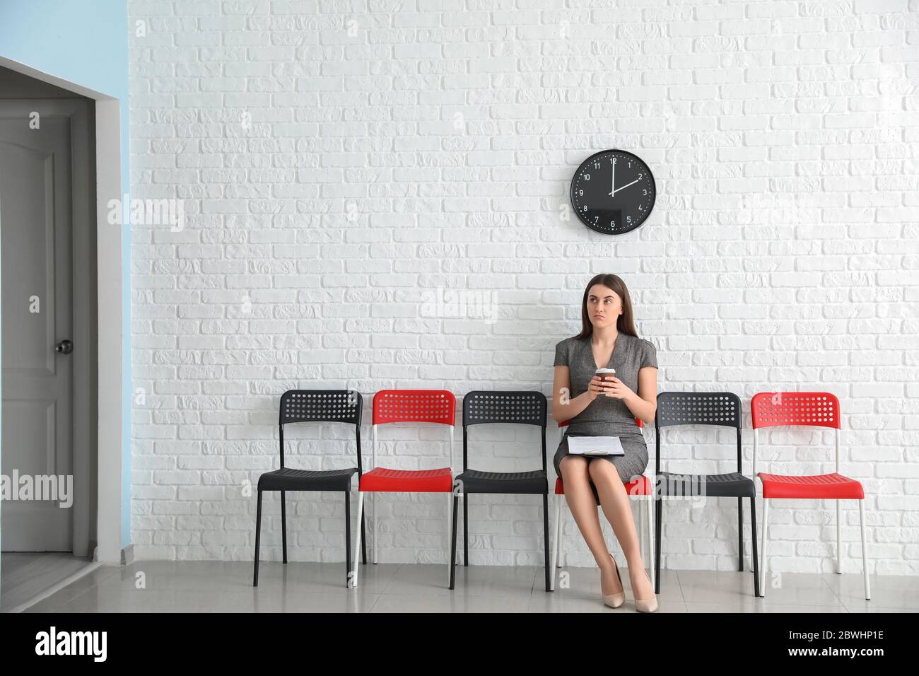 Young woman waiting for her turn indoors Stock Photo - Alamy