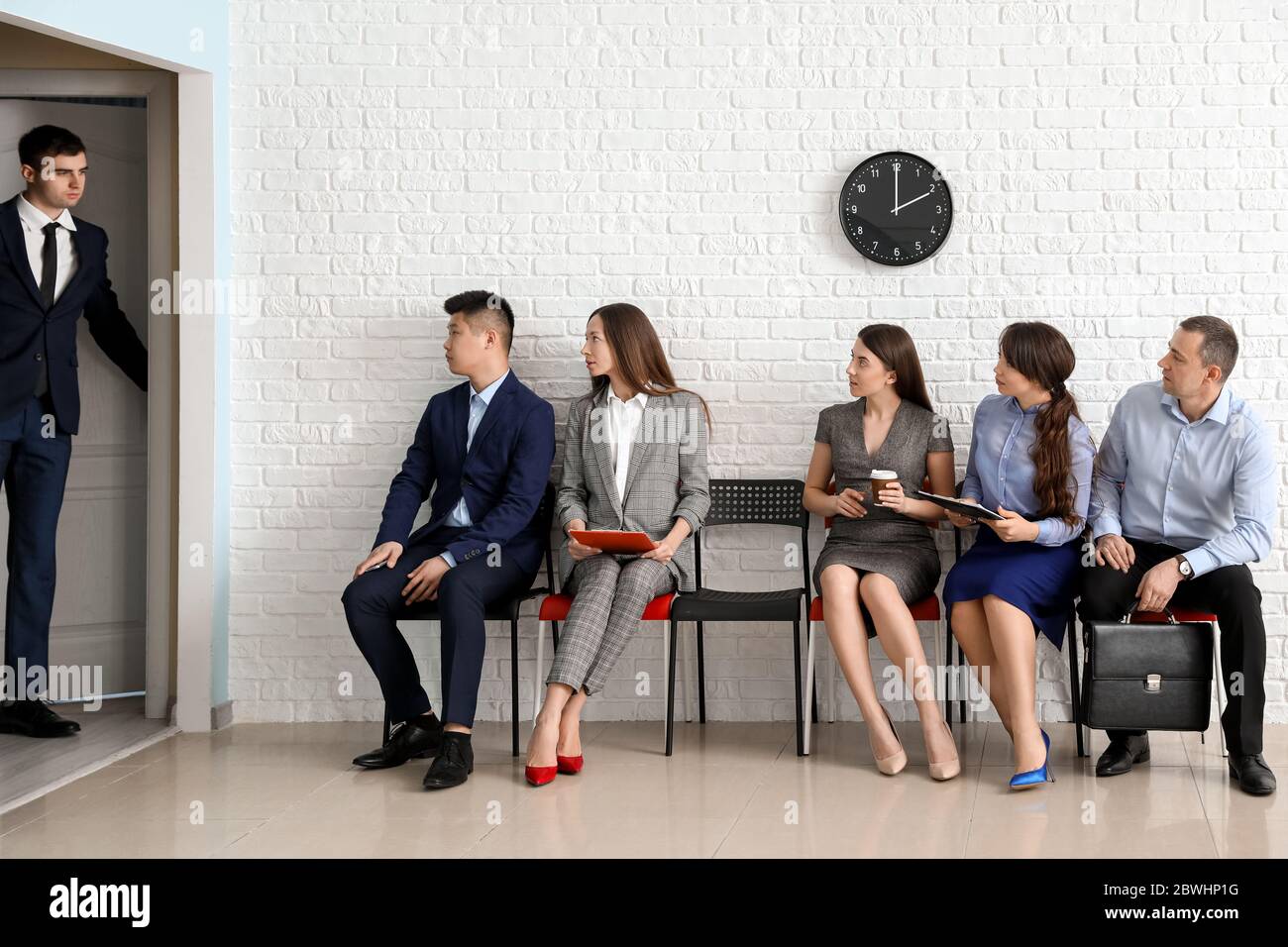 Business people waiting in line indoors Stock Photo - Alamy