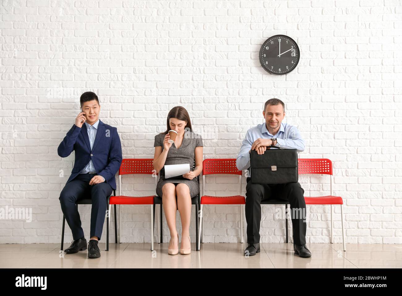 Business people waiting in line indoors Stock Photo - Alamy