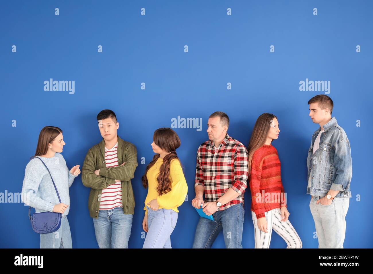 People waiting in line on color background Stock Photo - Alamy
