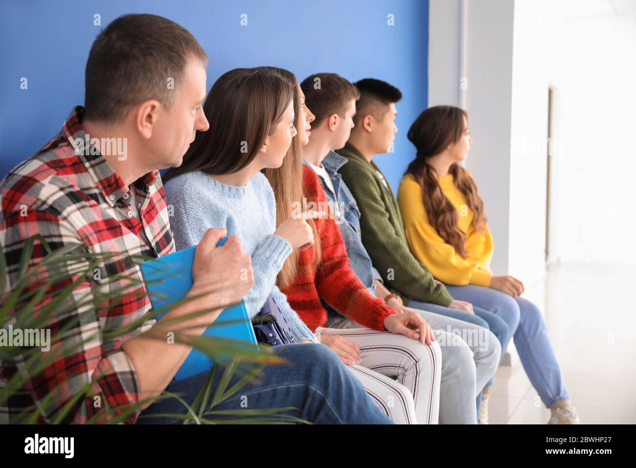 People waiting in line indoors Stock Photo - Alamy