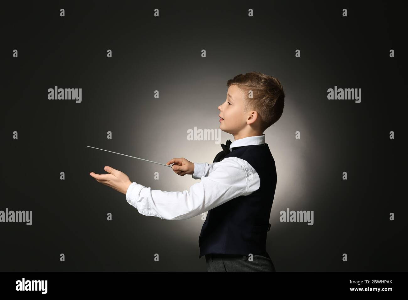 Little conductor on dark background Stock Photo - Alamy