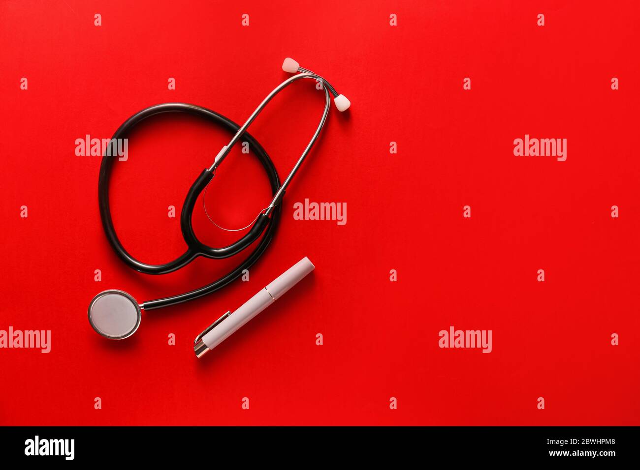 Modern flashlight with stethoscope on color background Stock Photo - Alamy