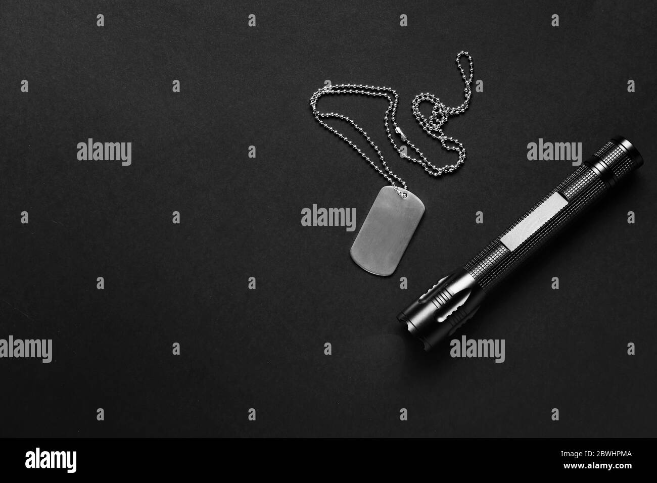 Modern flashlight with tag on dark background Stock Photo - Alamy