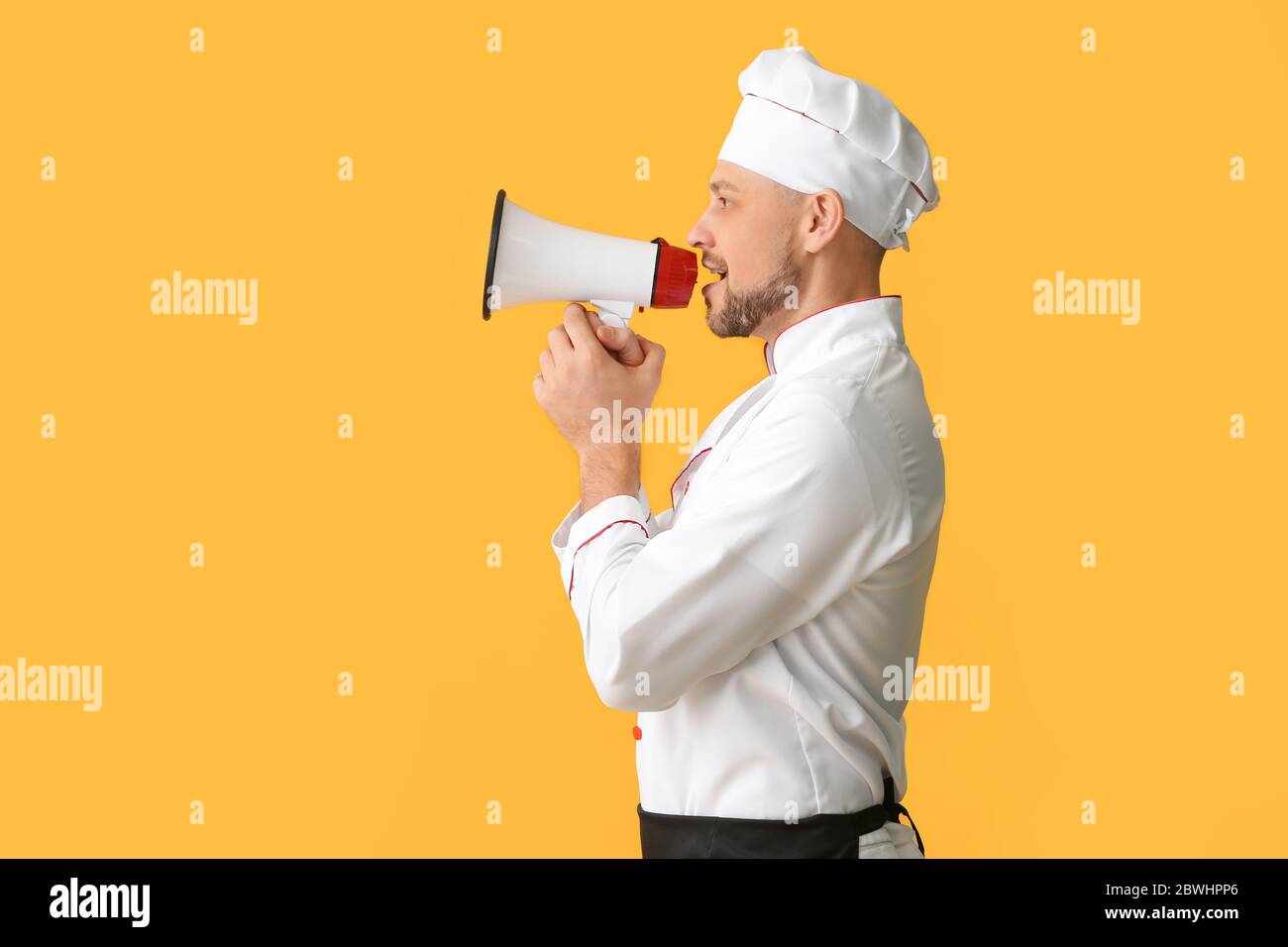 Portrait of male chef with megaphone on color background Stock Photo ...