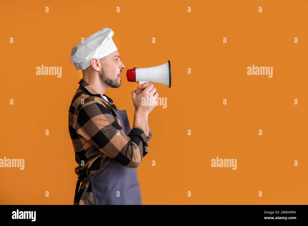 Portrait of male chef with megaphone on color background Stock Photo ...