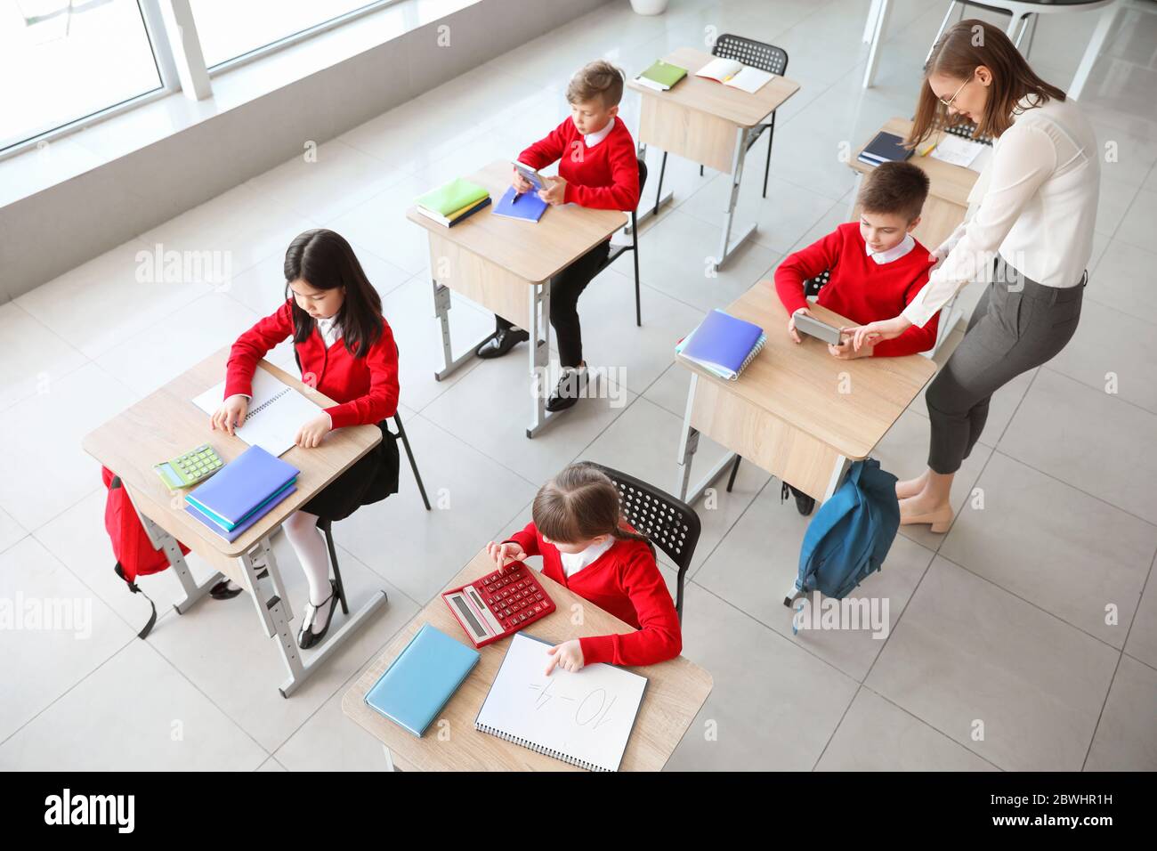 Children with math teacher during lesson in classroom Stock Photo - Alamy