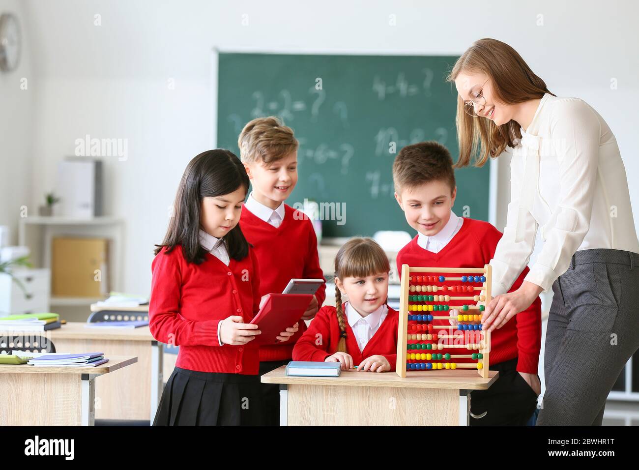 Children with math teacher during lesson in classroom Stock Photo - Alamy