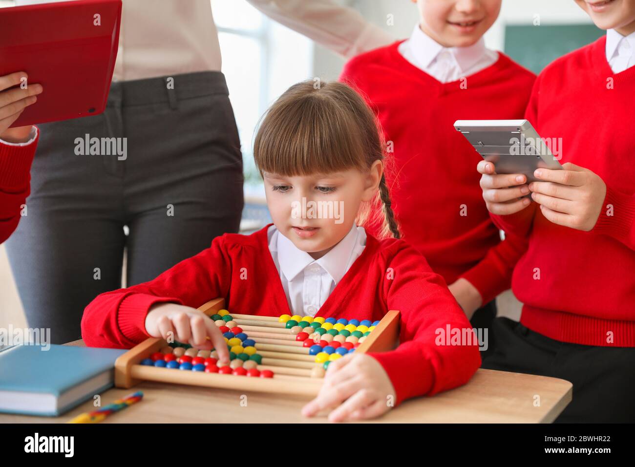 Children with math teacher during lesson in classroom Stock Photo - Alamy
