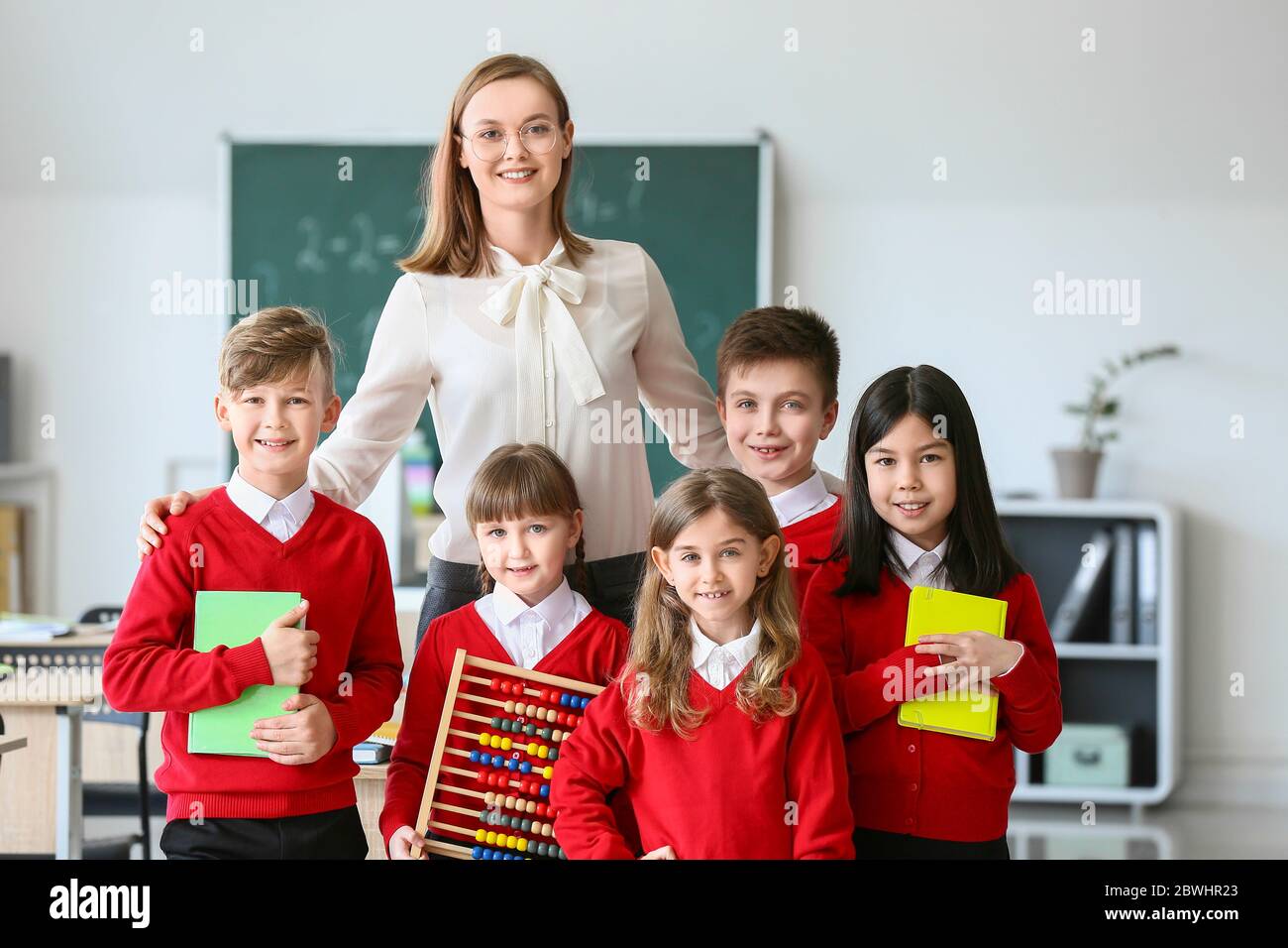 Children with math teacher during lesson in classroom Stock Photo - Alamy
