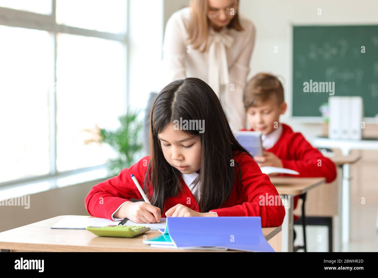 Little girl doing math task in classroom Stock Photo - Alamy