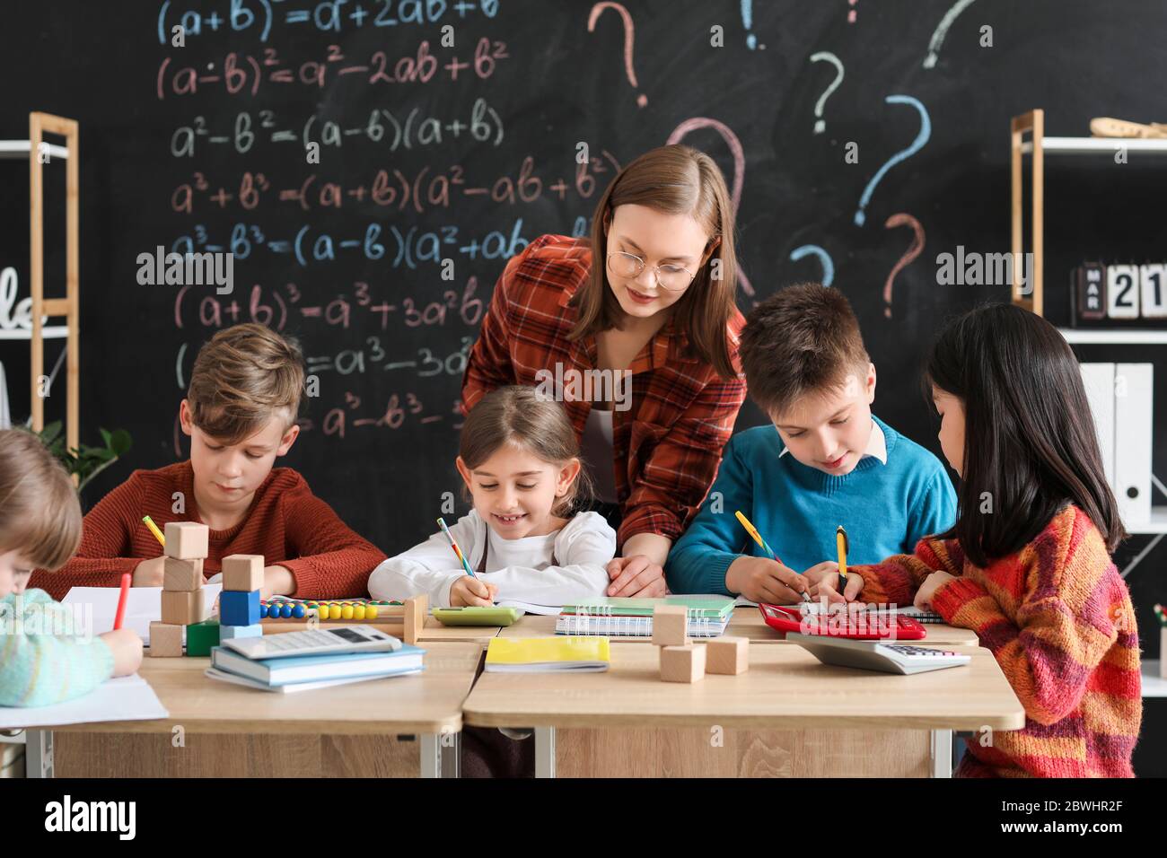 Children with math teacher during lesson in classroom Stock Photo - Alamy