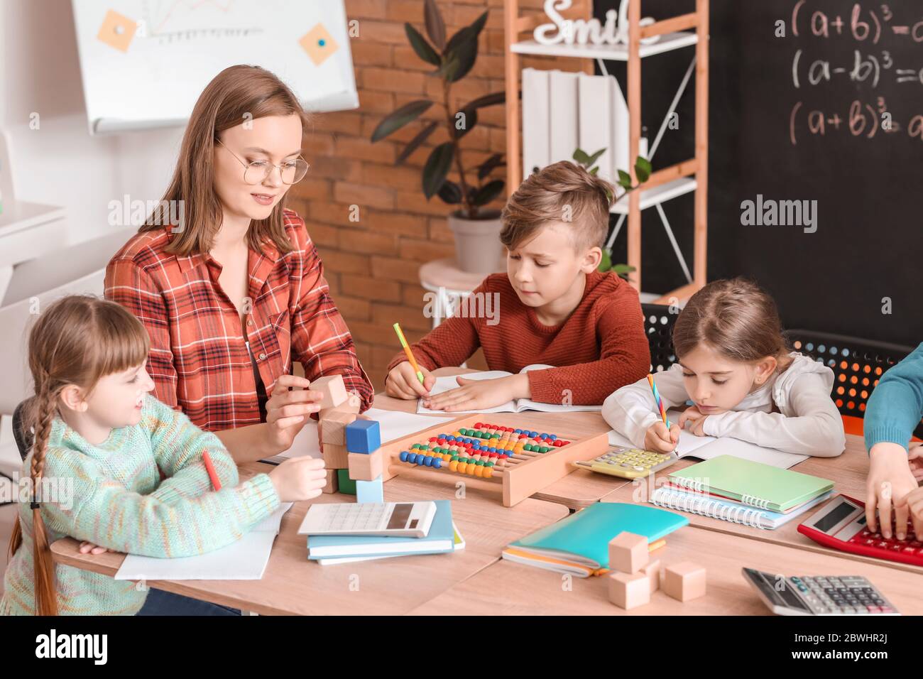 Children with math teacher during lesson in classroom Stock Photo - Alamy