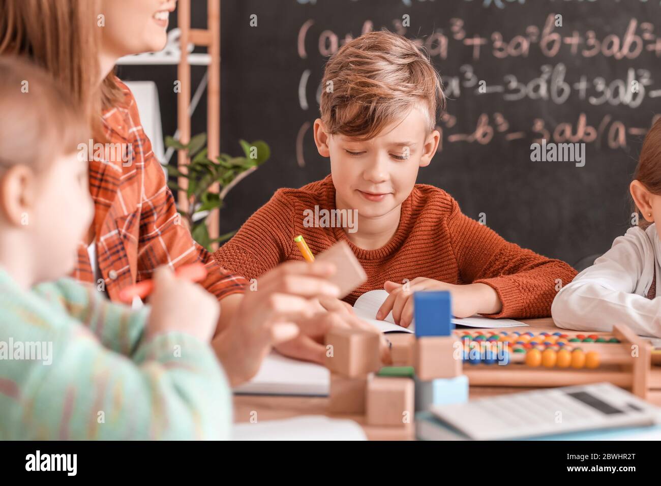 Children with math teacher during lesson in classroom Stock Photo - Alamy