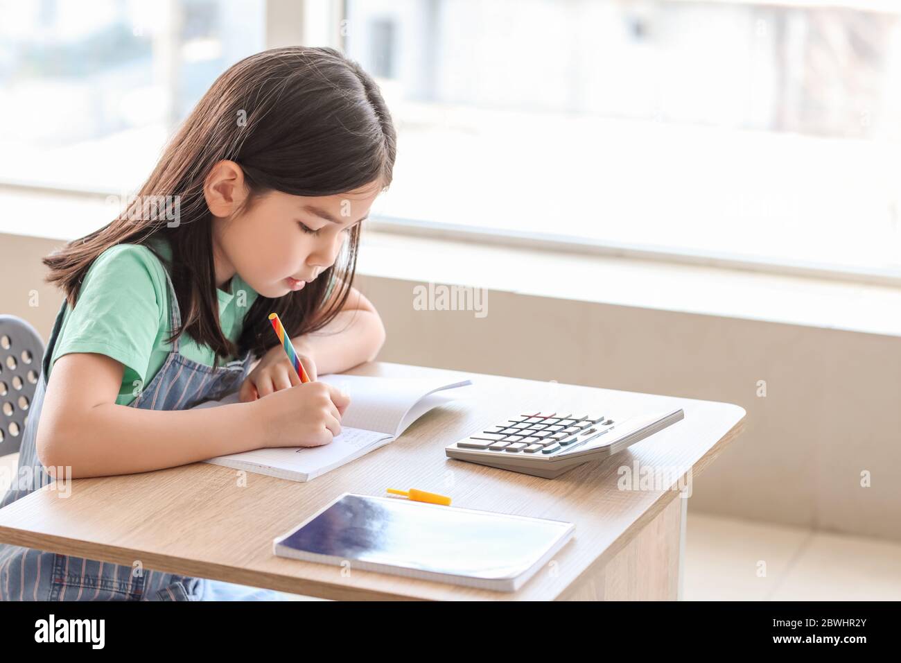 Little girl doing math task in classroom Stock Photo - Alamy