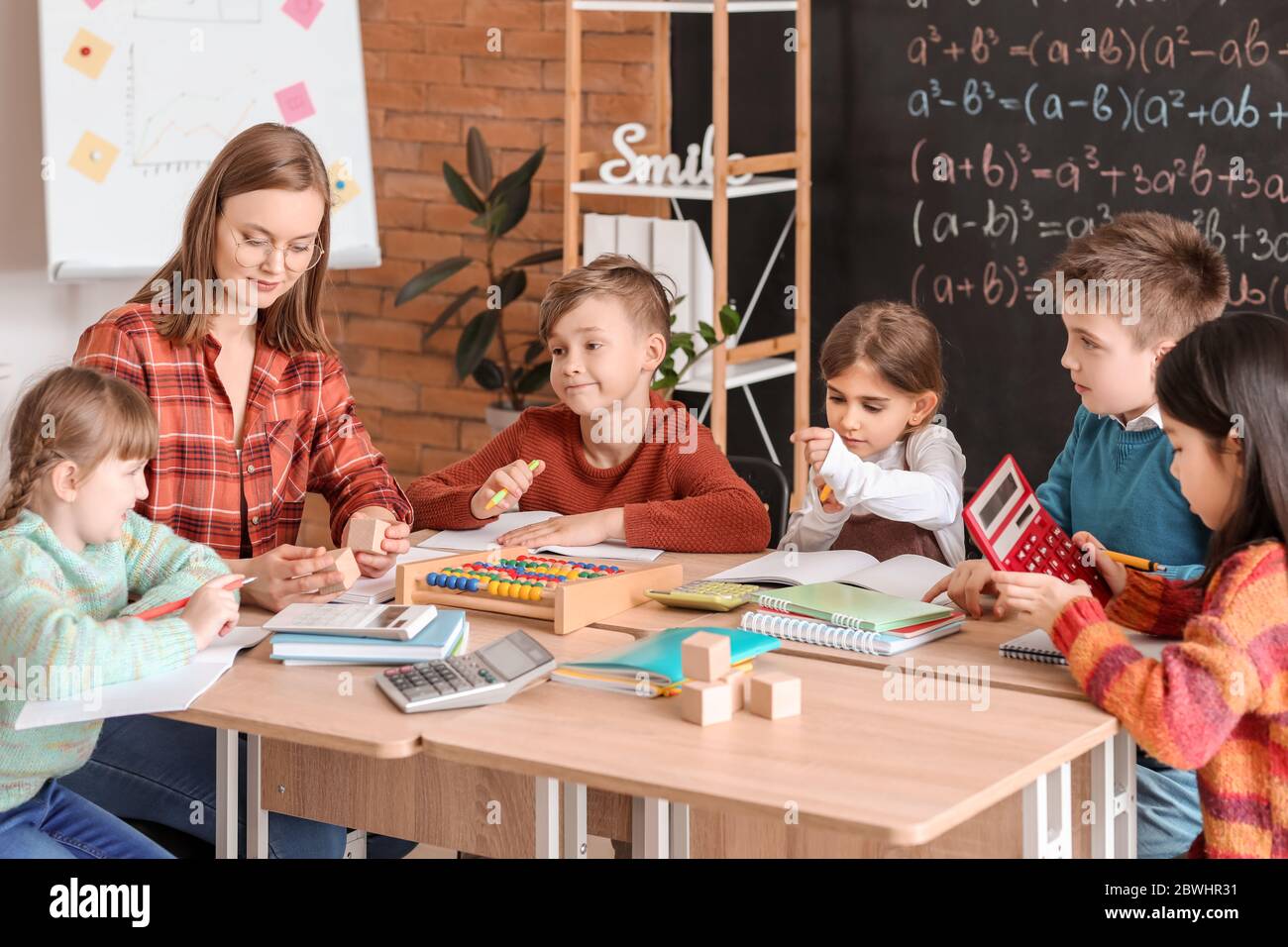 Children with math teacher during lesson in classroom Stock Photo - Alamy
