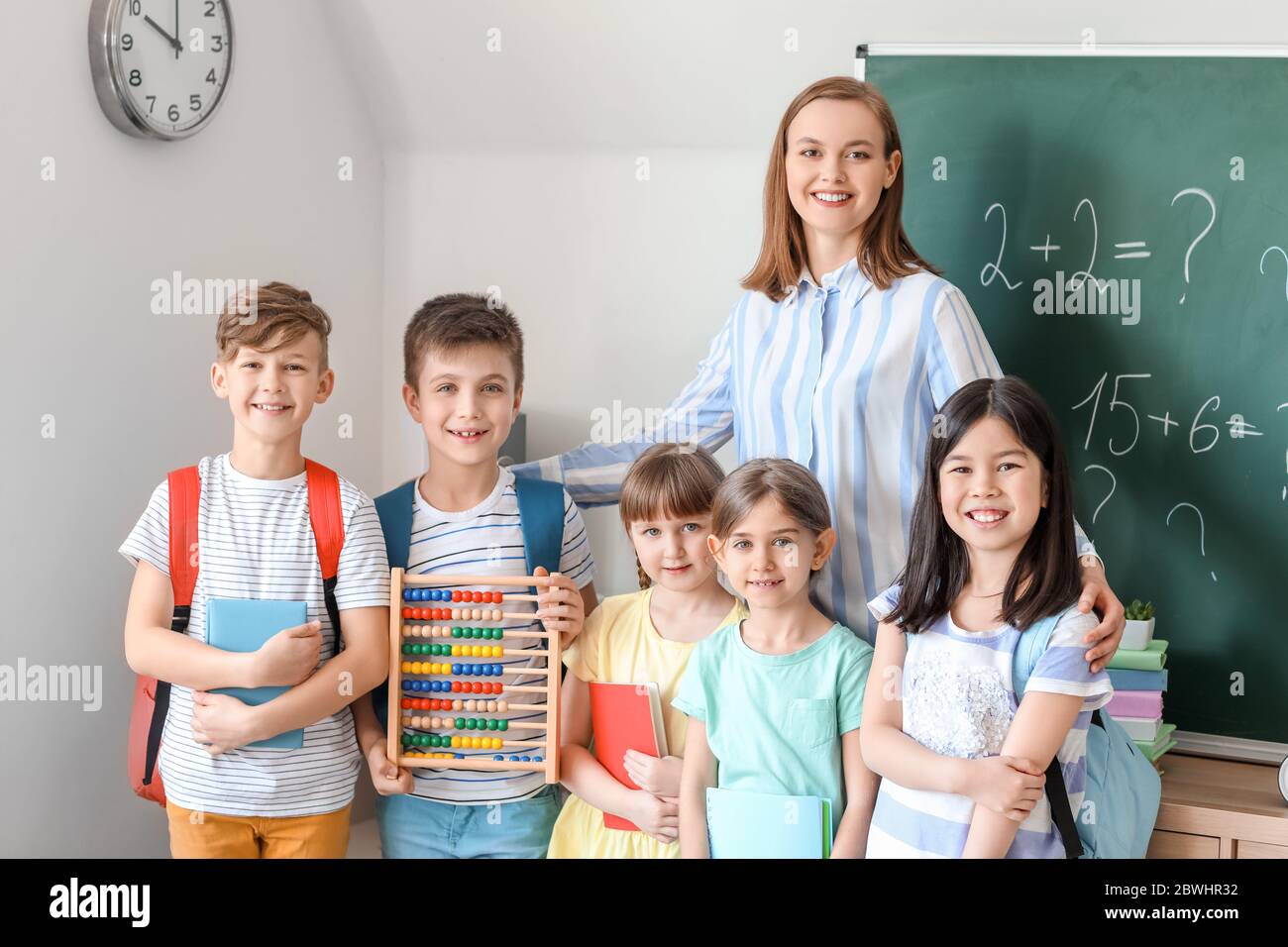 Children with math teacher during lesson in classroom Stock Photo - Alamy