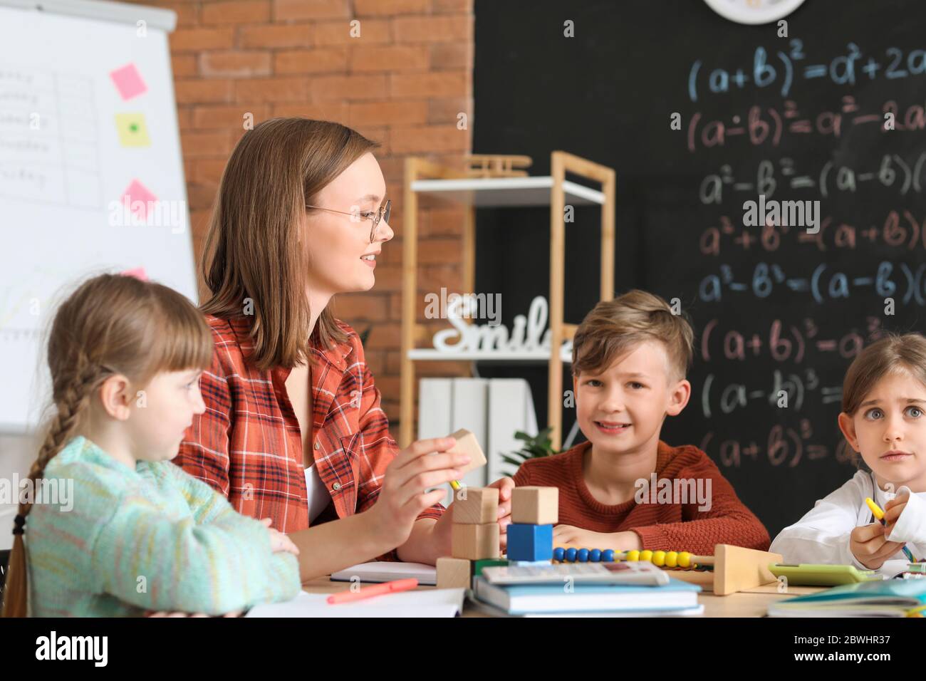 Children with math teacher during lesson in classroom Stock Photo - Alamy