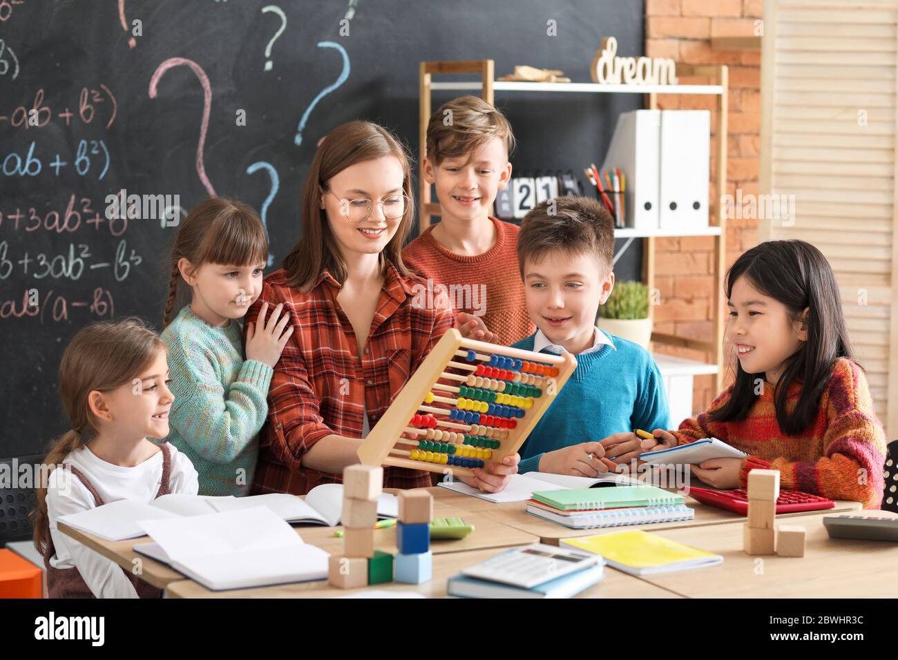 Children with math teacher during lesson in classroom Stock Photo - Alamy