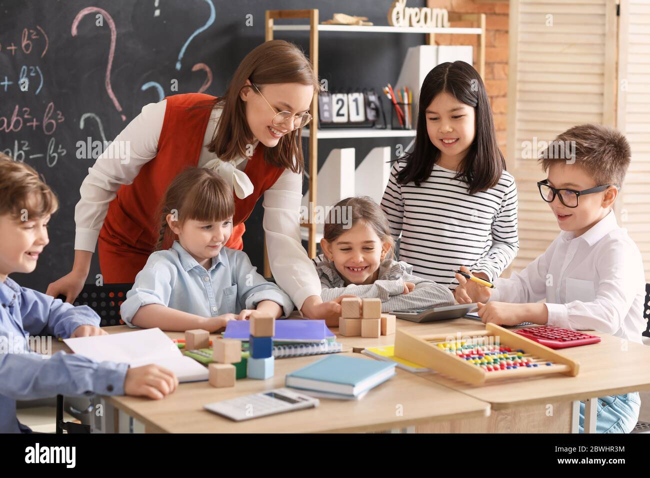 Children with math teacher during lesson in classroom Stock Photo - Alamy
