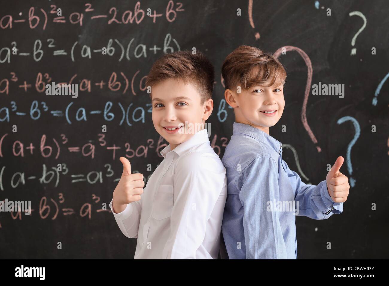 Little boys near school blackboard in classroom Stock Photo - Alamy