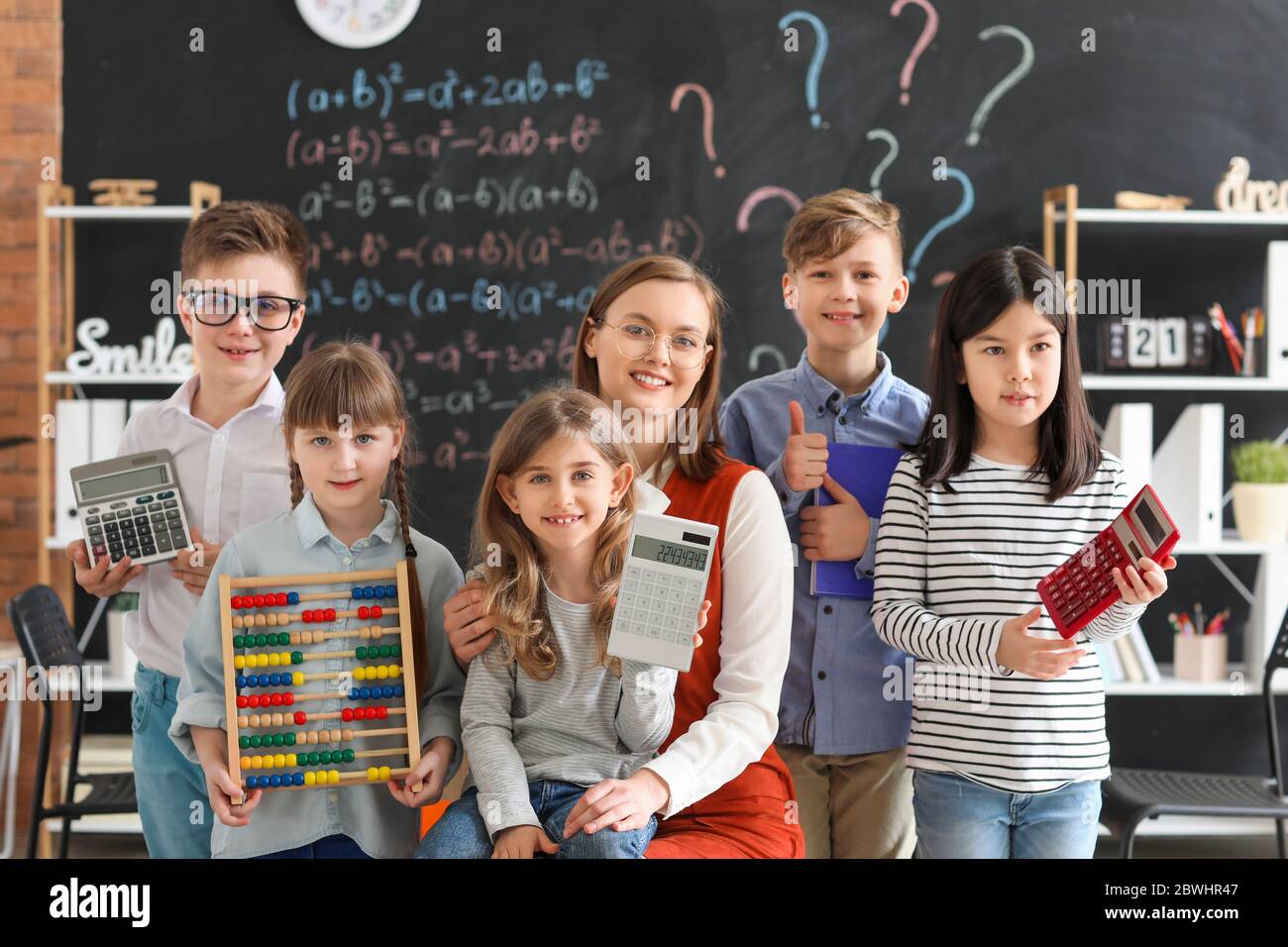 Children with math teacher during lesson in classroom Stock Photo - Alamy