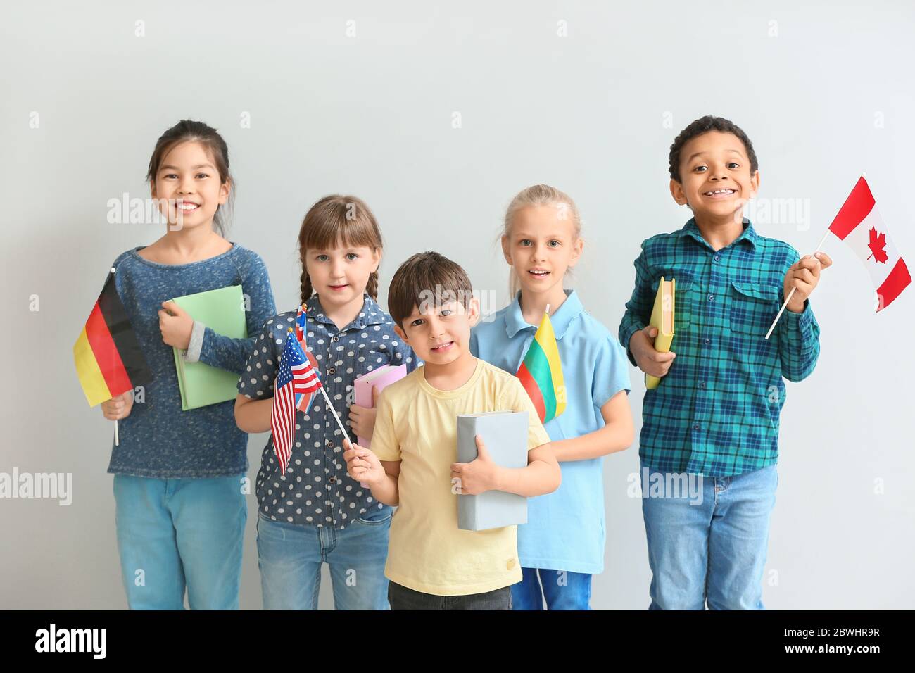 Little pupils of language school on light background Stock Photo - Alamy