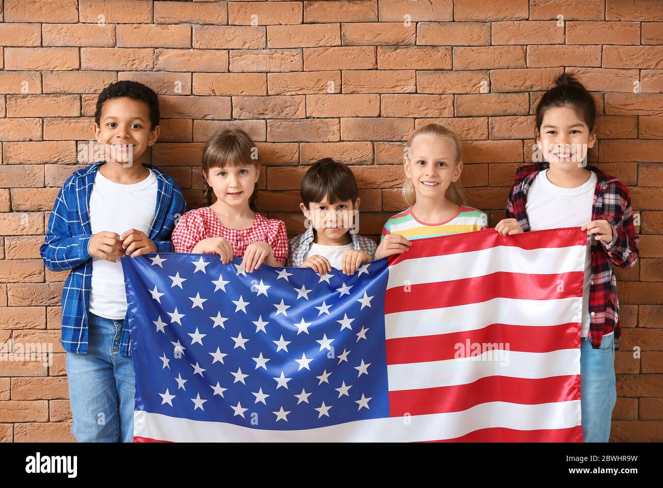 Little children with flag of USA on brick background Stock Photo - Alamy