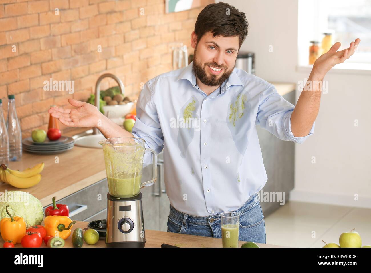 Clumsy man with spilled smoothie in kitchen Stock Photo - Alamy