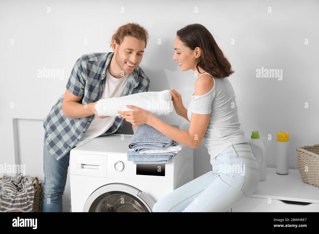 Happy young couple doing laundry at home Stock Photo - Alamy
