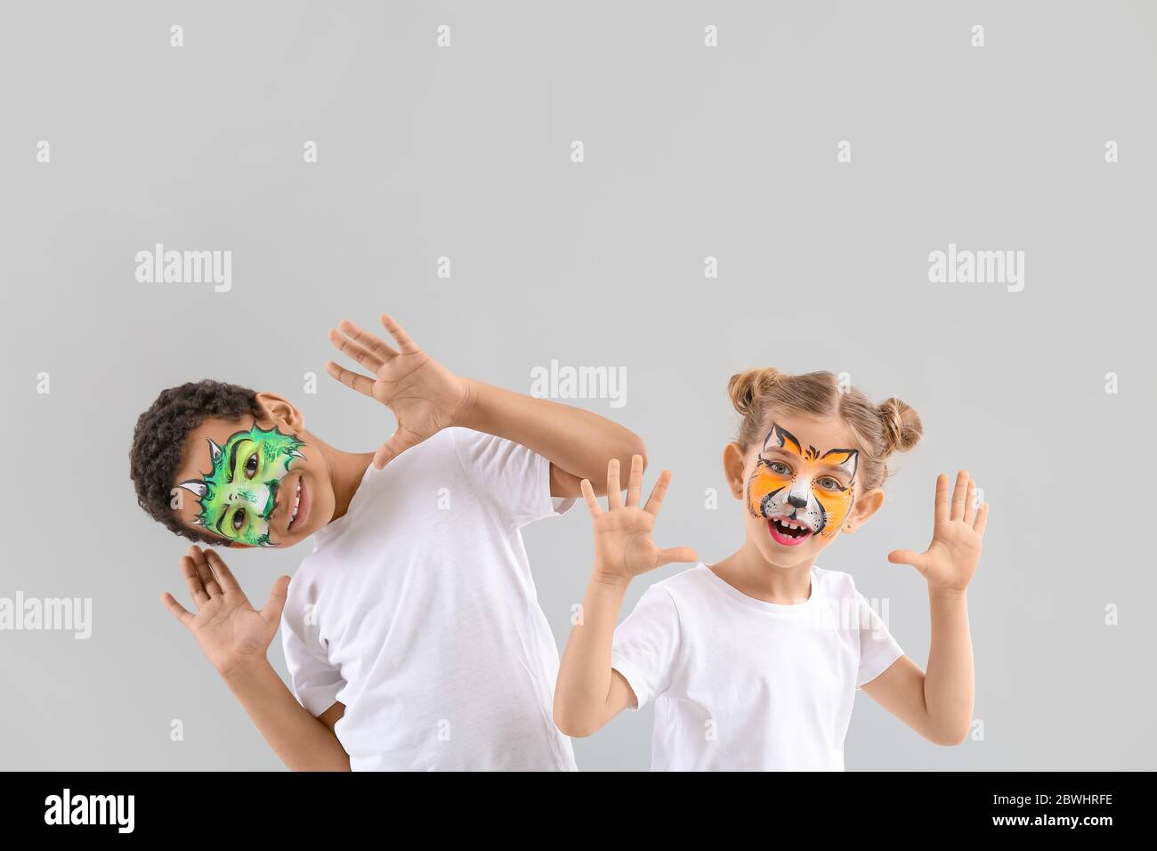 Funny children with face painting on light background Stock Photo - Alamy