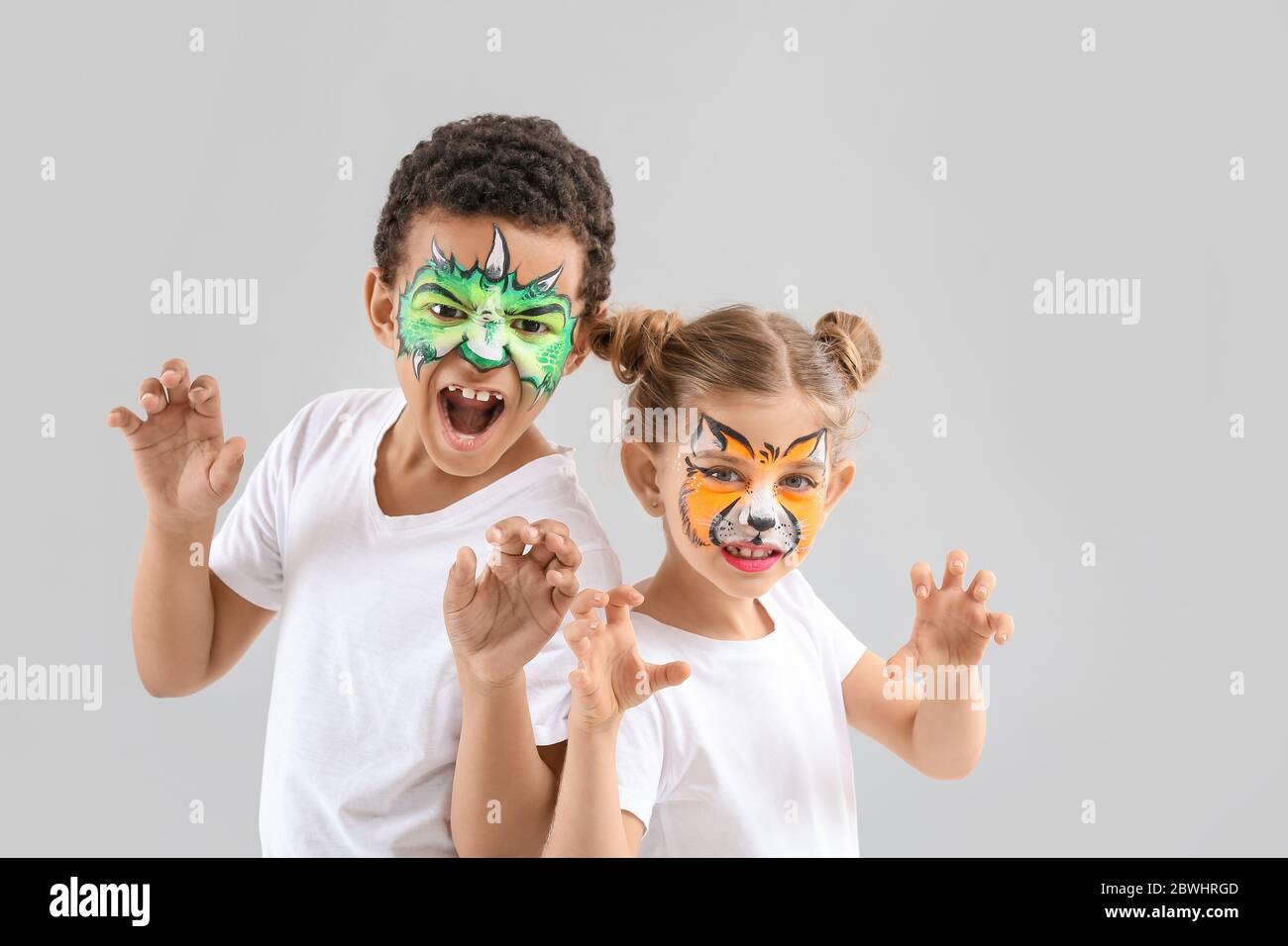 Funny children with face painting on light background Stock Photo - Alamy